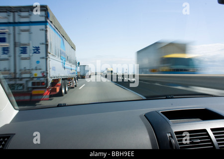 Trucks driving with speed along the highway behind some small autumn ...