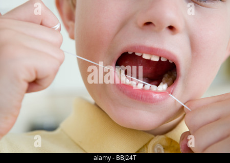 A small boy using Dental floss to care for teeth and gums Stock Photo ...