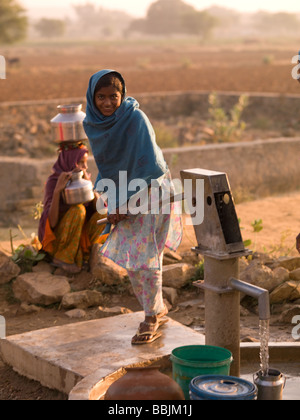 Girls pumping water from the well Stock Photo - Alamy