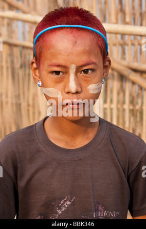 A portrait of a young trendy Burmese man with tanaka on his face ...