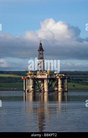 Scotland, Invergordon. Oil rig platform being pulled out to sea by tug ...