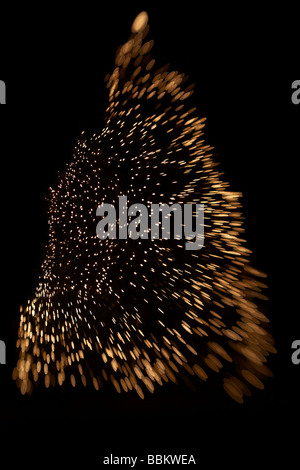 A vertical shot of illuminated Christmas lights wrapper around a tree ...