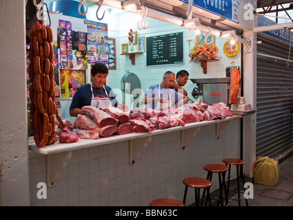 3 Mexican butchers cutting and cleaning meat in a butcher shop at the ...