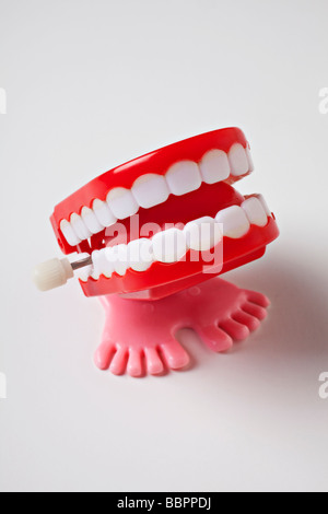 A plastic toy mouth with teeth and tongue on a light blue background ...