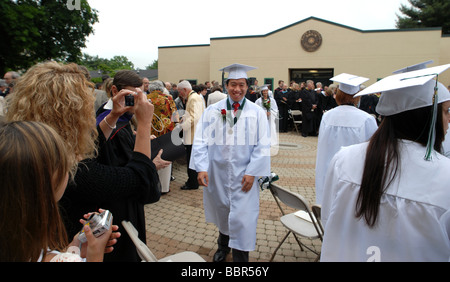 High school graduates get their picture taken during a commencement ...