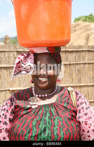 African woman. Carrying a bucket on her head Stock Photo - Alamy