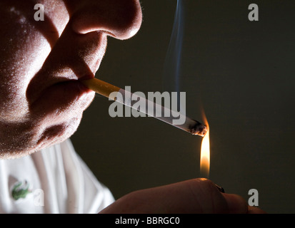 A smoker smokes a Rothmans cigarette made by British American Tobacco ...