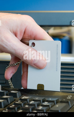 Computer access card being slotted into card reader built into laptop ...