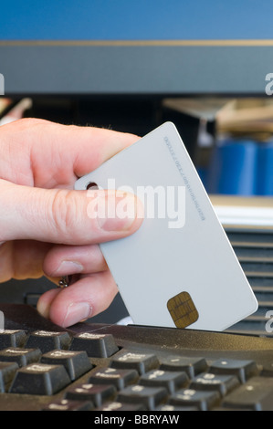 Computer access card being slotted into card reader built into laptop ...