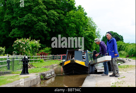 The crew of a barge negotiate their way through the gates at Tyrley ...