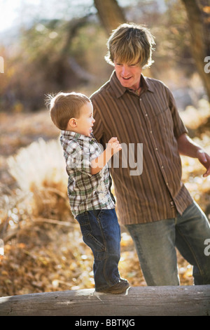 Father guiding young son on log Stock Photo: 24513837 - Alamy