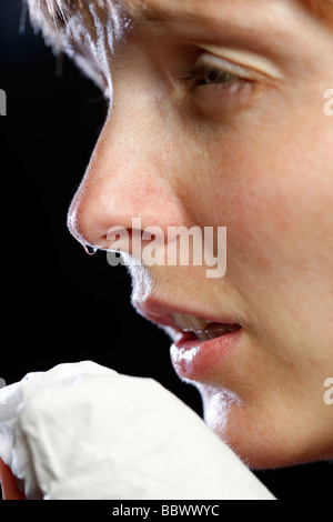 Woman is sneezing sniveling, has a cold or an allergy, uses a soft ...