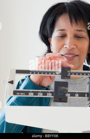 Woman adjusting scale Stock Photo - Alamy