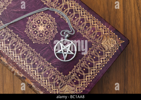 Silver necklace with inverted pentagram on an old book Stock Photo - Alamy