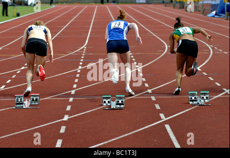Runners leaving starting blocks, rear view Stock Photo - Alamy