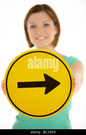 Young woman holding a direction sign Stock Photo - Alamy
