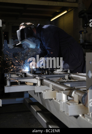 A mechanic repairs a car chassis. A man removes car wheels using a ...