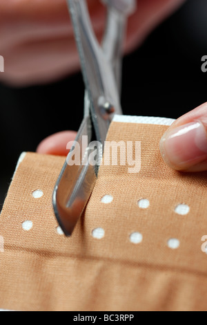 Plaster cutting to apply the plaster to a little wound Stock Photo - Alamy