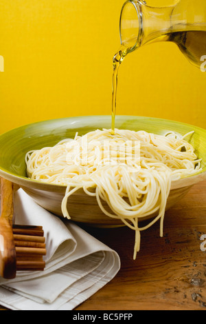 A dish of spaghetti with spaghetti server and olive oil Stock Photo - Alamy