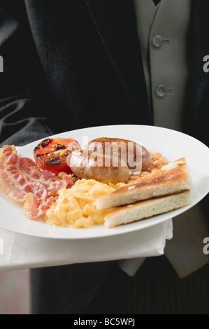 Butler serving English breakfast on plate with dome cover Stock Photo ...
