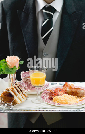 Butler serving English breakfast on tray Stock Photo - Alamy