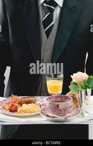 Butler serving English breakfast on tray Stock Photo - Alamy