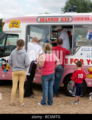 People queuing for Ice Cream Van on an suburban street in sunshine ...