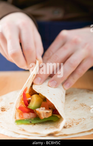 Folding a chicken wrap Stock Photo - Alamy
