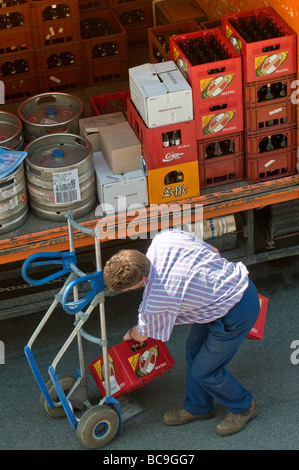 Beer delivery driver loading crates on/off 2-wheeled truck - France ...