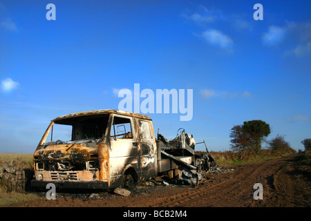 Burnt out truck left abandoned on common ground. View of the side ...