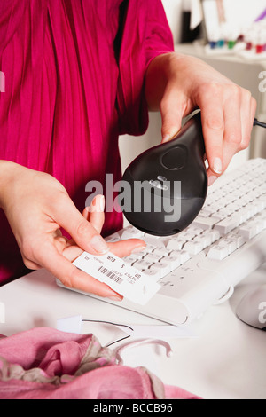 Close-up of female cashier scanning cost label on pack of red ripe ...