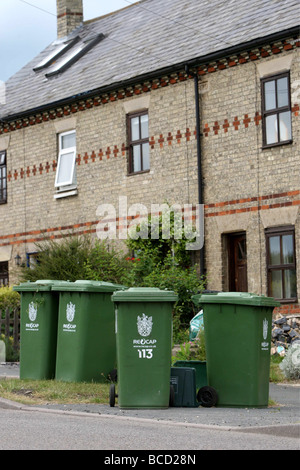 Black and green wheelie bins outside a brick terraced house covered in ...