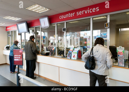 People at the counter inside an English Post Office, Suffolk UK Stock ...