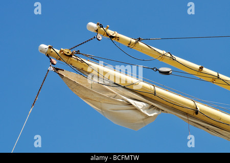 Yardarm of a tall ship with furled sail rigging and block and tackle ...