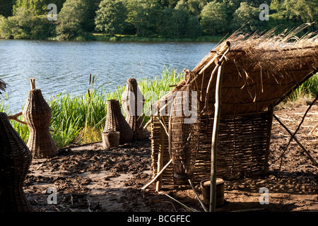 Primative living in stick and reed huts by a lake Stock Photo - Alamy