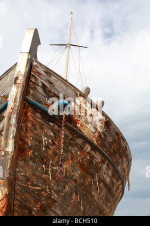 An large, old, wrecked wooden boat, in dry dock, showing the rotting ...