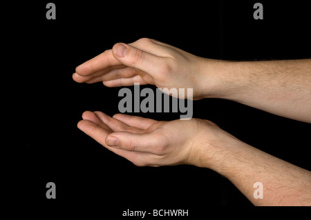 male hands enclosing and encompassing and cupping against black Stock ...