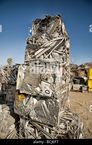 crushed and compacted cubes of metal and aluminum cans at a scrap metal ...