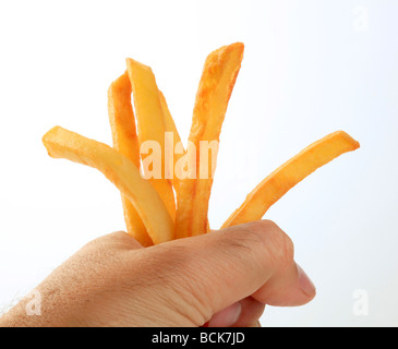 Man's hand holding French fries - closeup Stock Photo - Alamy