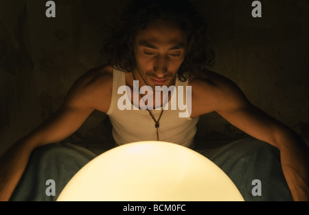 Man looking at glowing orb Stock Photo - Alamy