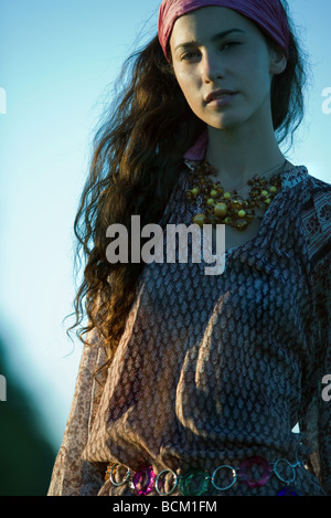 Camera headed woman standing on green grass against modern cityscape ...