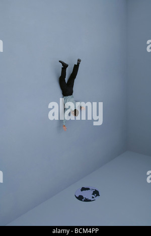 Casual young man falling down above dark city light in mountains with ...