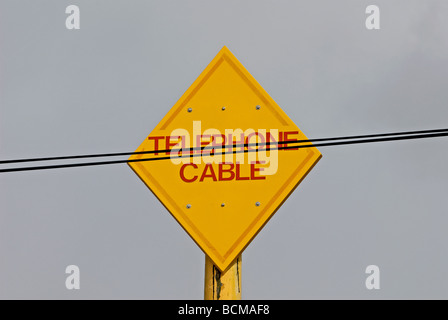A yellow warning marker sign for an underground telephone cable ...