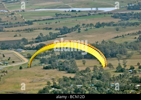 Paragliding with canopy fully inflated and pilot navigating to landing ...