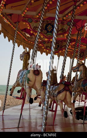 Seafront merry-go-round and funfair stalls on the beach on a sunny ...