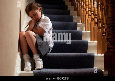 young girl upset sad and lonely holding head in hands crying huddled ...