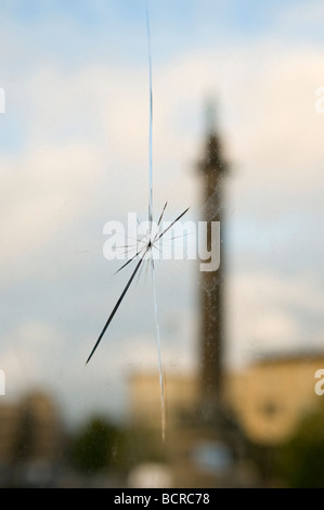 A hole in the window glass with a bullet during a military shooting ...