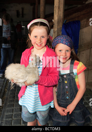 Two sisters with a chicken Stock Photo - Alamy