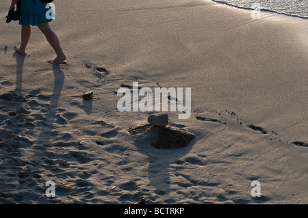 A woman walking across the beach at Sennen Stock Photo - Alamy