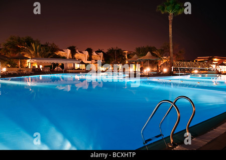 luxury resort with pool at night view. hotel outdoor landscape with ...